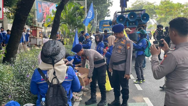 Polisi Bagikan Air Mineral Dan Permen Untuk Massa Buruh Di DPR